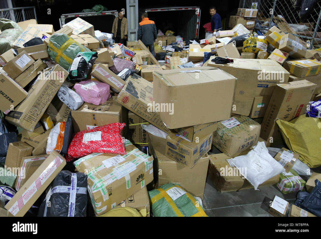 Chinese workers sort piles of parcels, most of which are from Singles ...