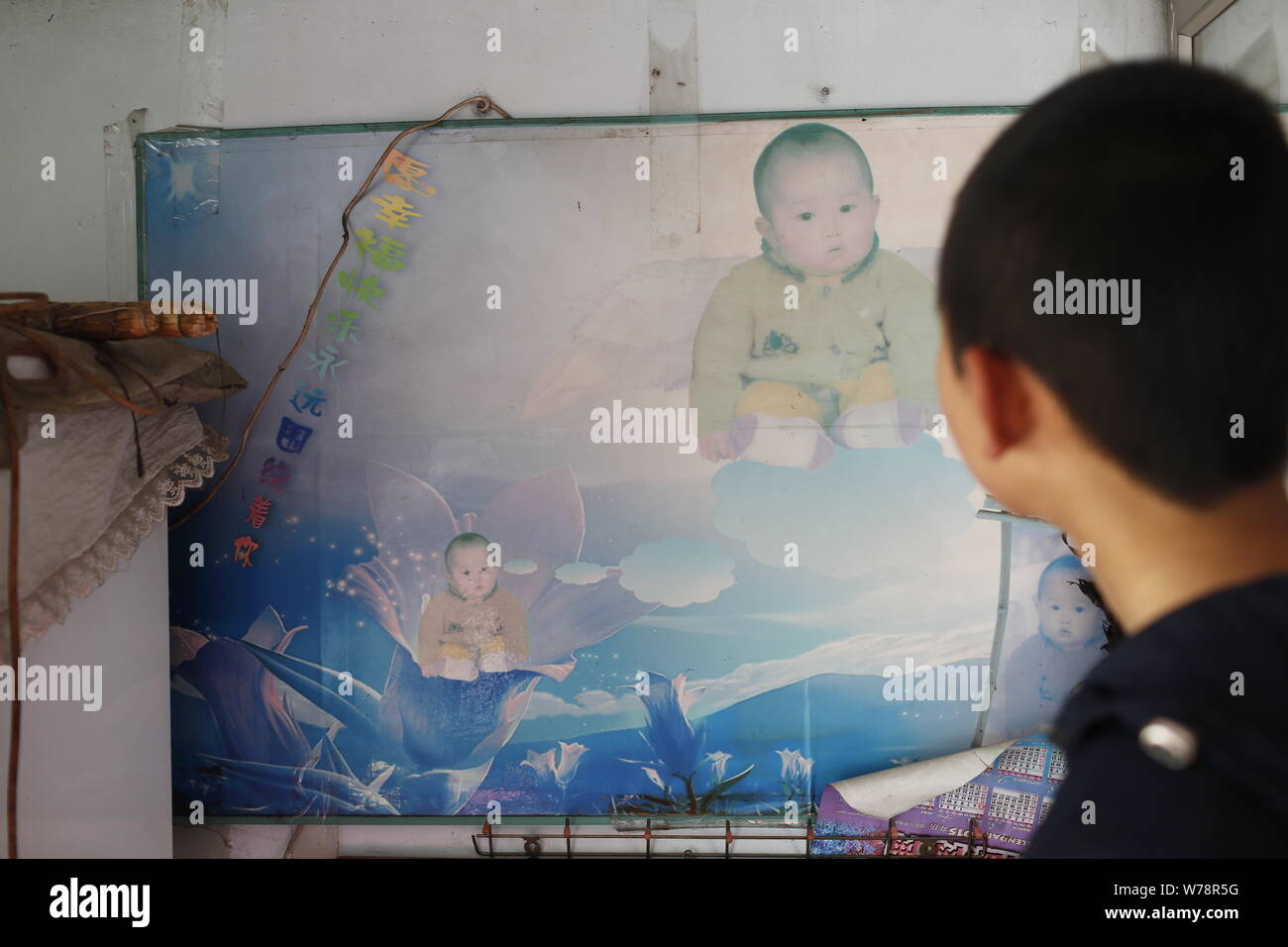 The 15-year-old Chinese boy looks at his childhood photo at home in a ...