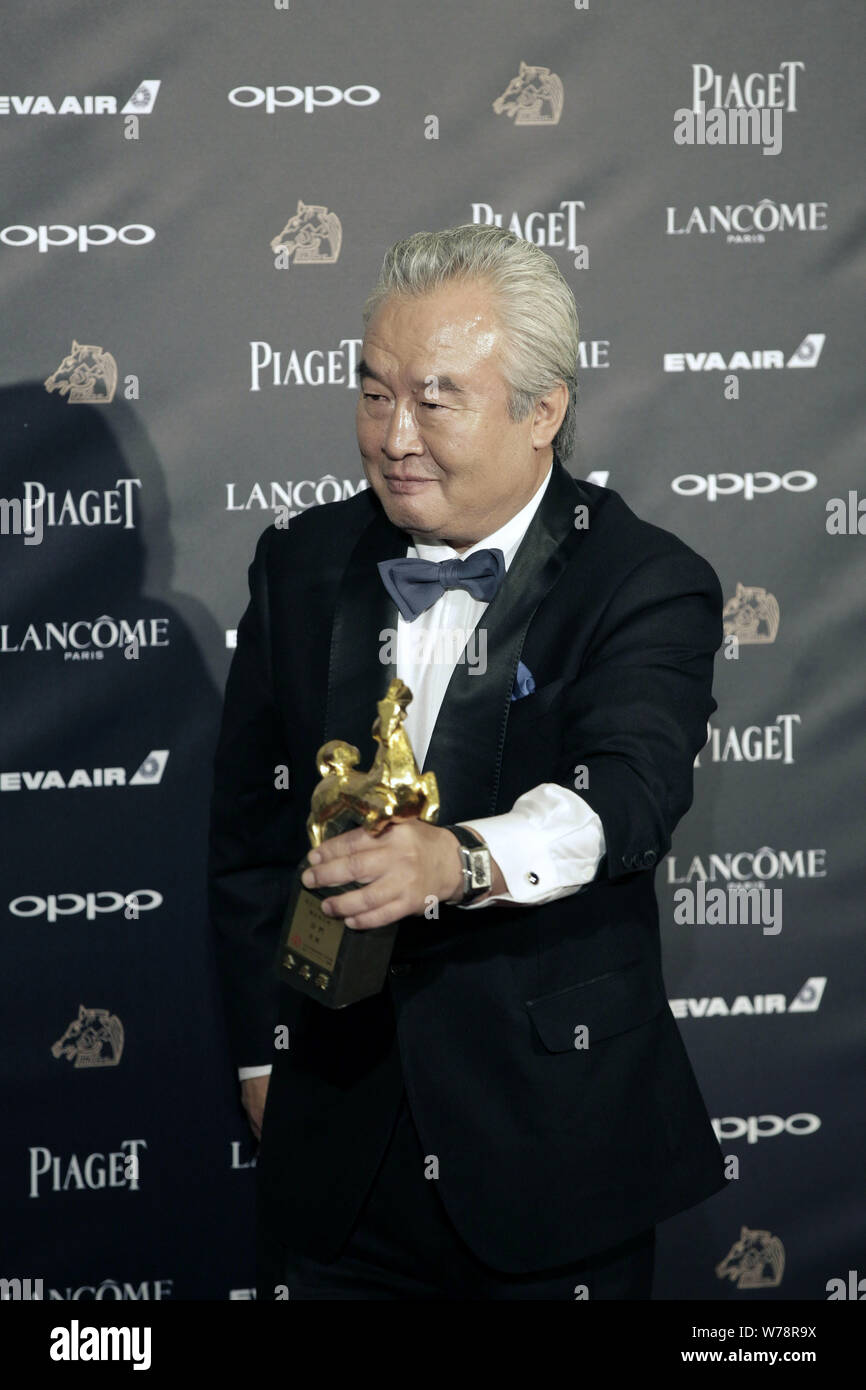 Chinese actor Tu Men poses with his trophy of the Best Leading Actor ...