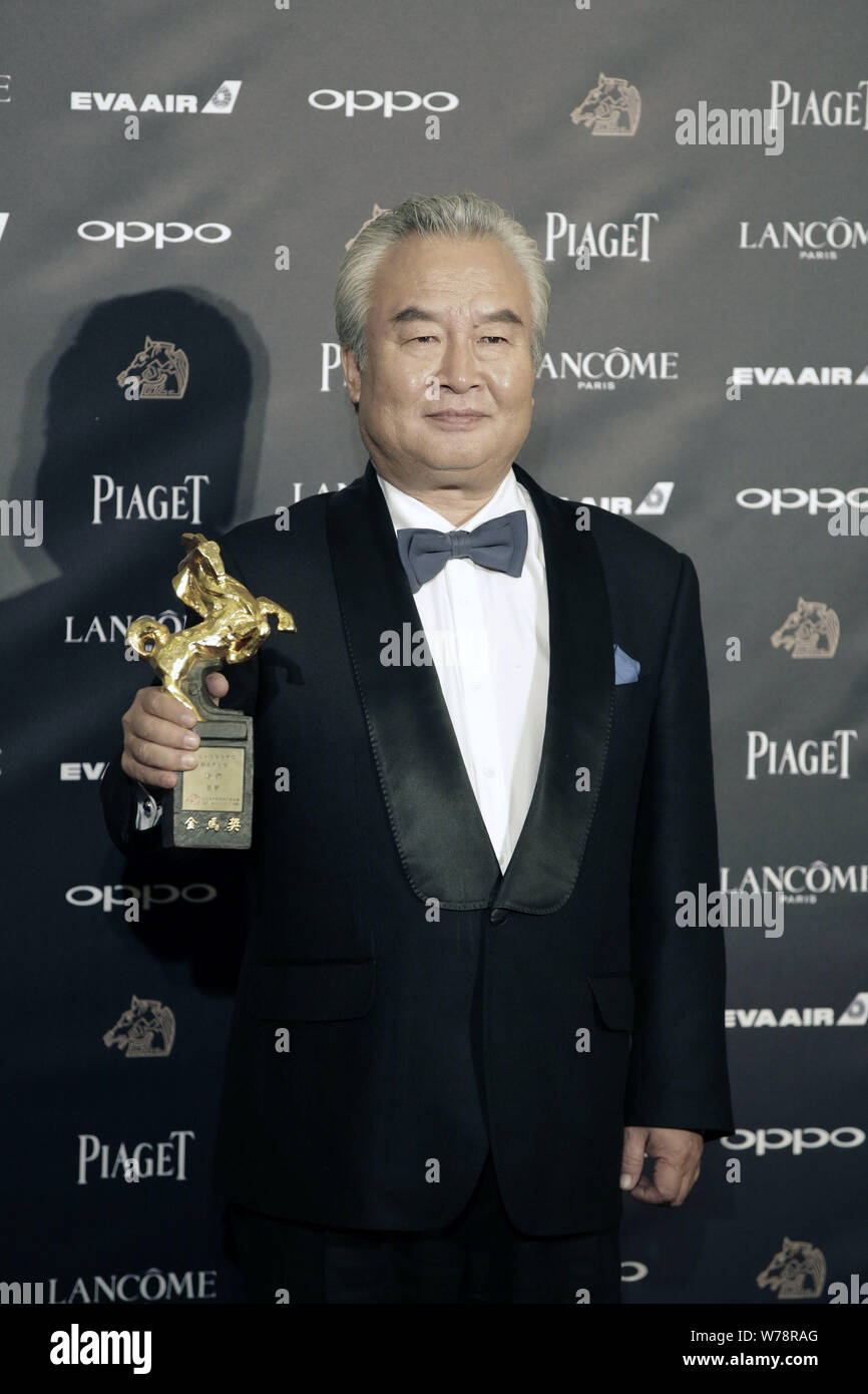 Chinese actor Tu Men poses with his trophy of the Best Leading Actor ...