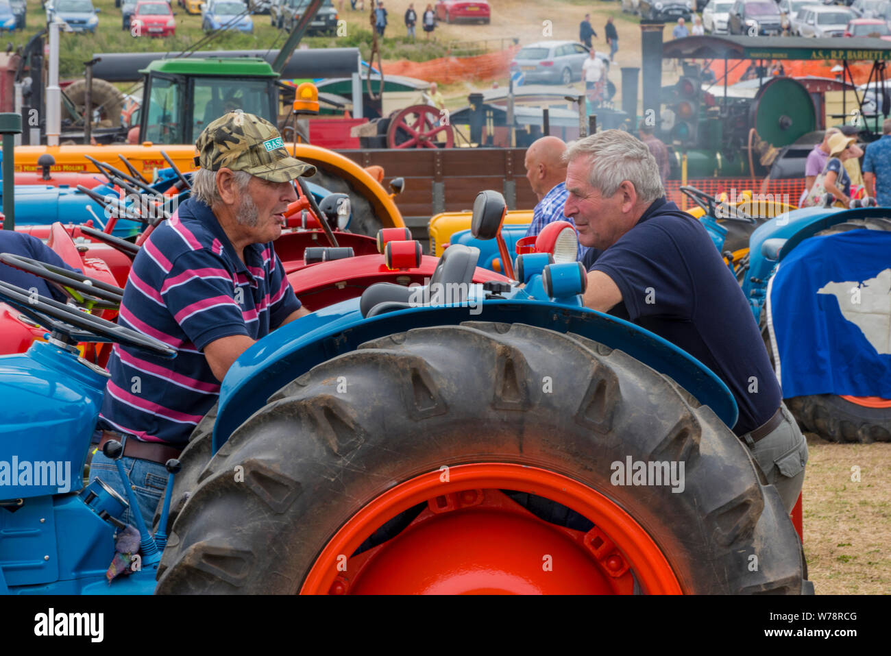 two old gentlemen farmers or tractor enthusiasts chatting or talking ...