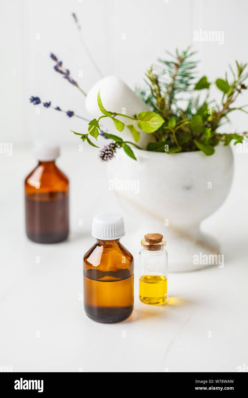 Preparation of essential oil. Different herbs in a mortar and bottles ...