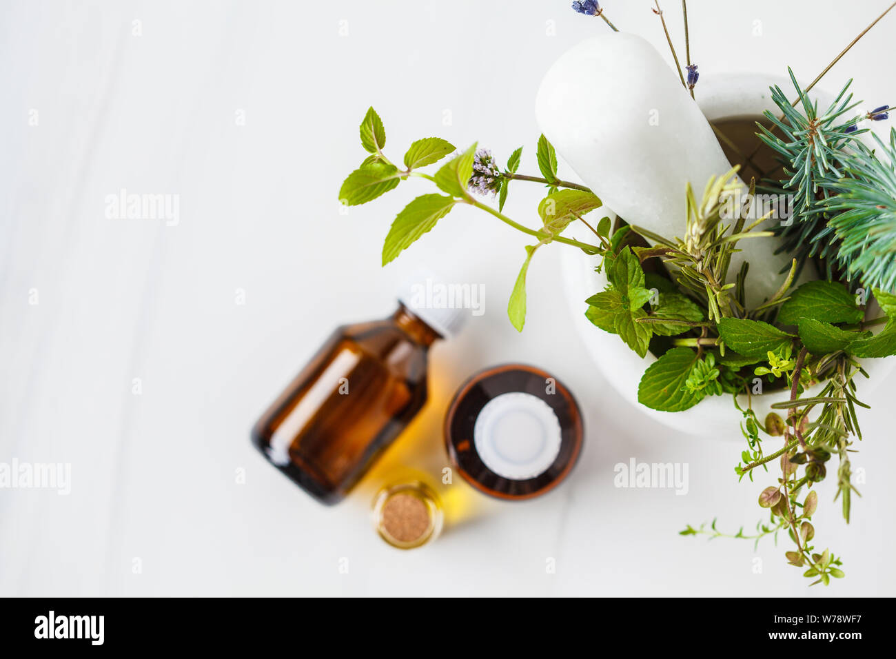 Preparation of essential oil. Different herbs in a mortar and bottles ...