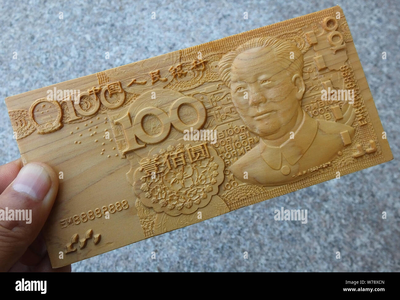 An exhibit shows a wooden carving version of the fifth edition of 100 ...