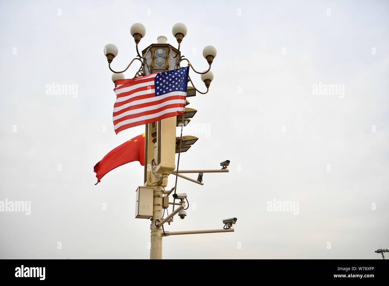 Chinese and American national flags flutter on a lamppost in front of ...