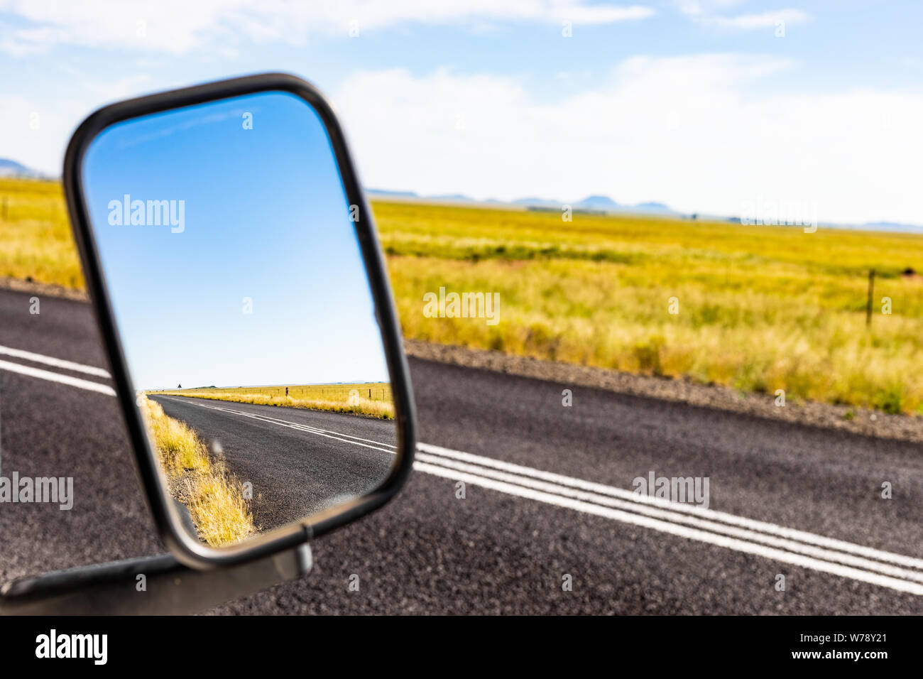 Reflection in a side mirror of a country road behind a 4x4 vehicle ...