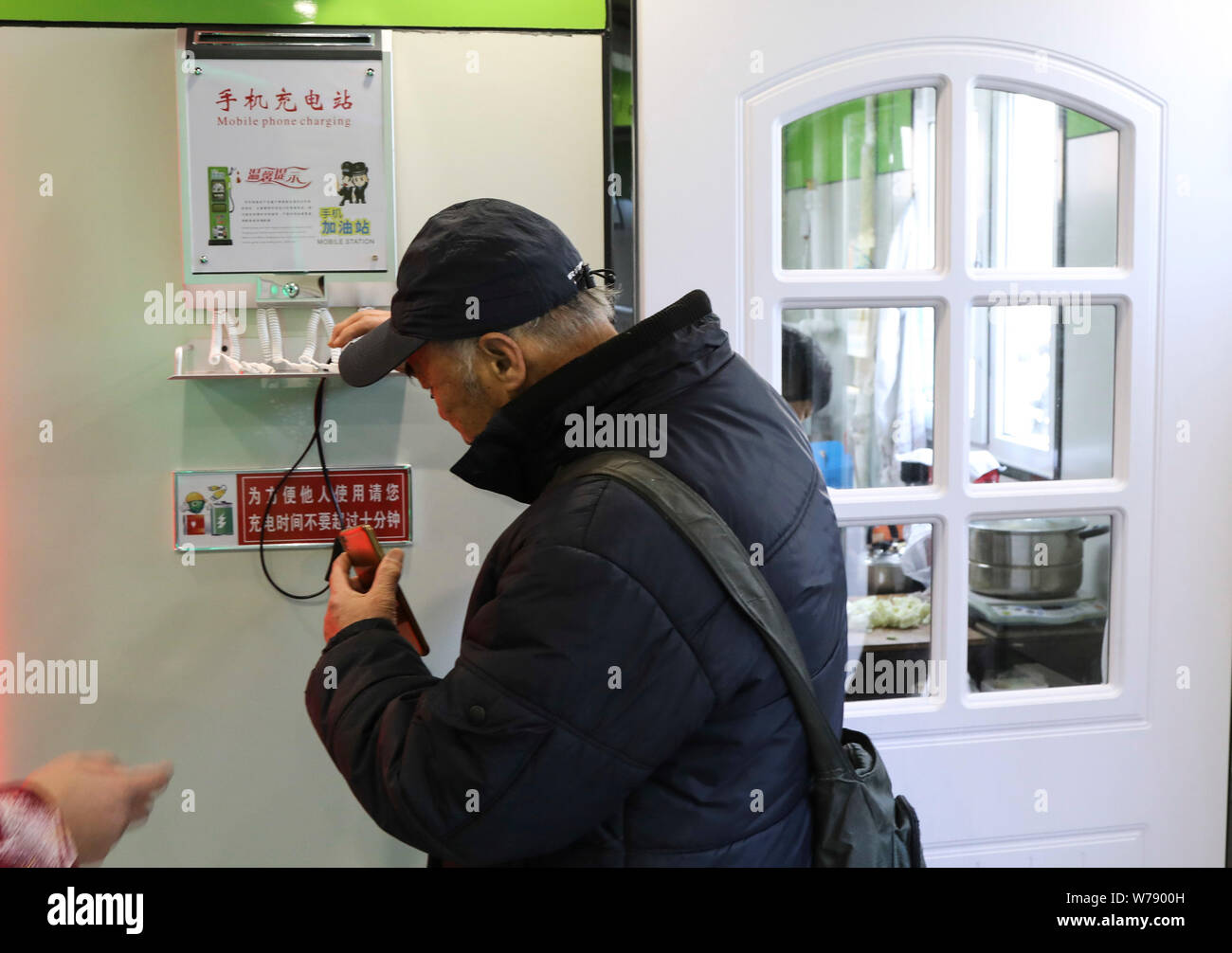 A Chinese man tries to recharge his smartphone through a mobile phone ...