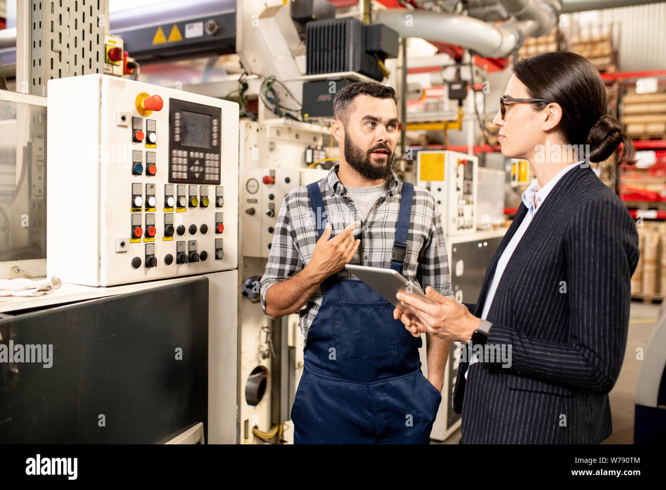 Engineer of processing factory explaining something to female business ...