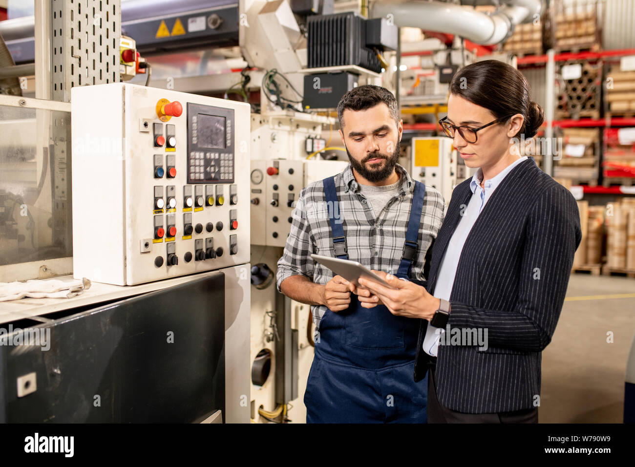 Young engineer and female business partner searching for technical data ...