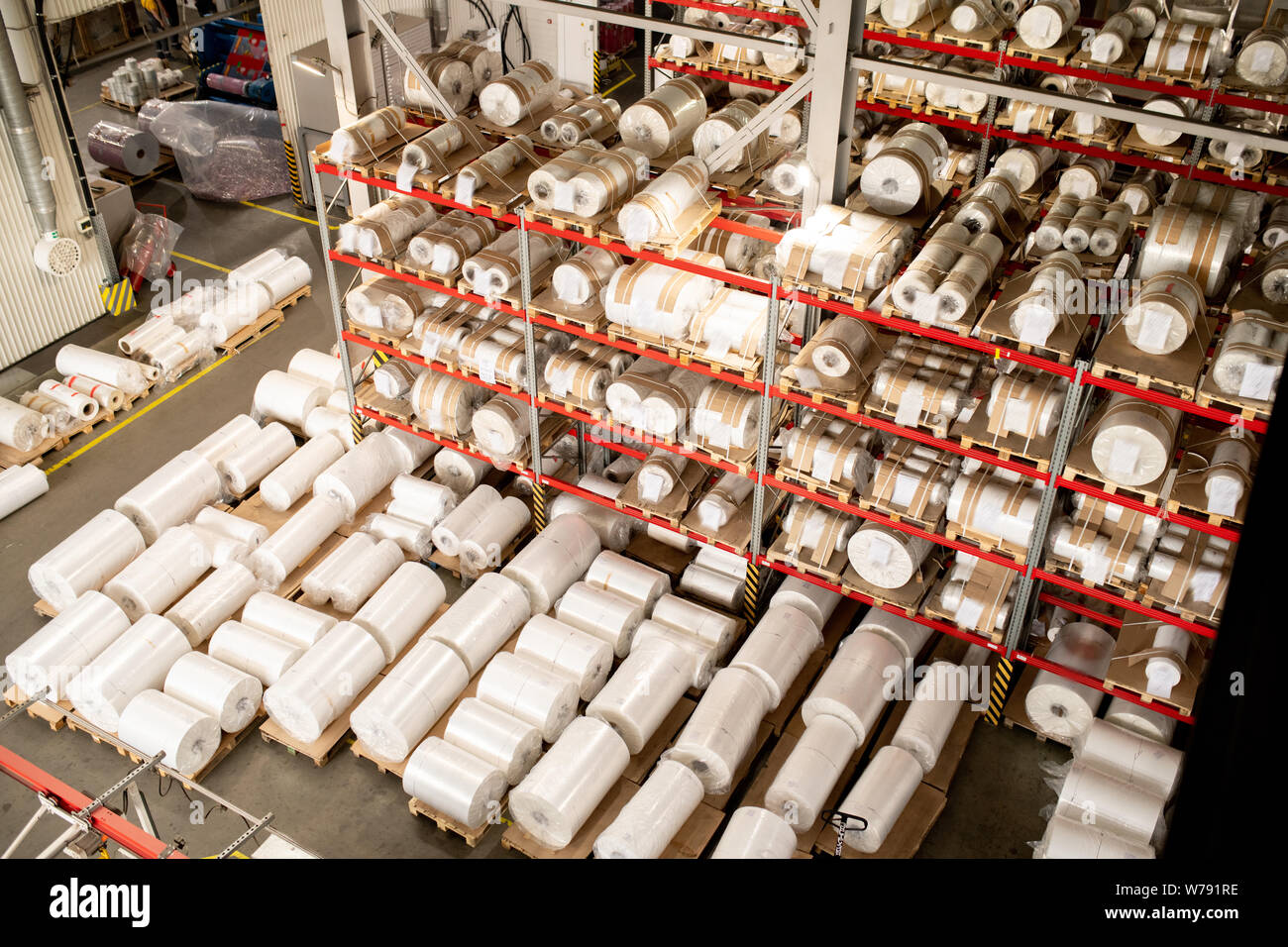 Many rolled polyethylene film units on shelves and racks inside ...