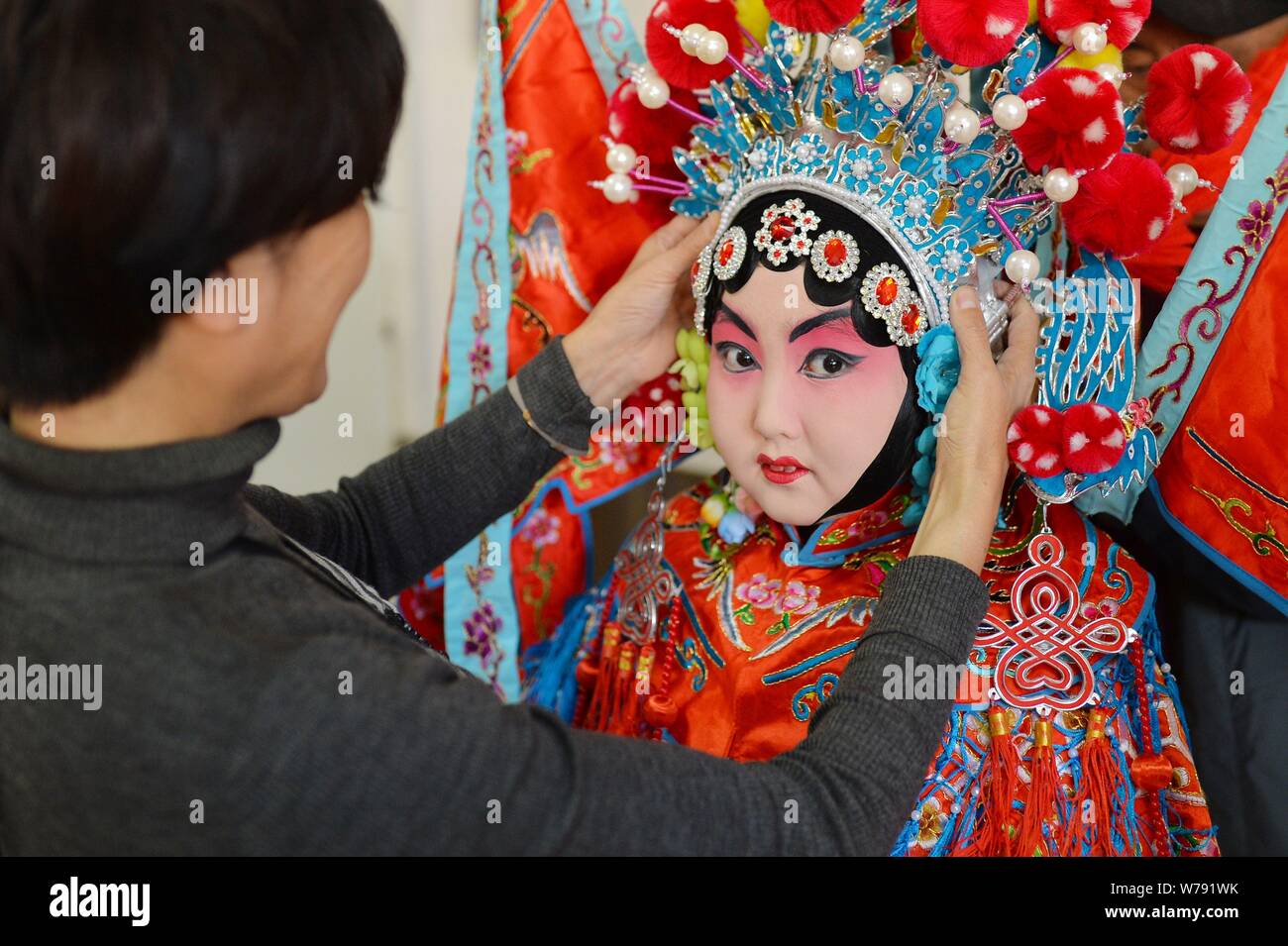A primary student finishes her hair and makeup dressed as the role of ...