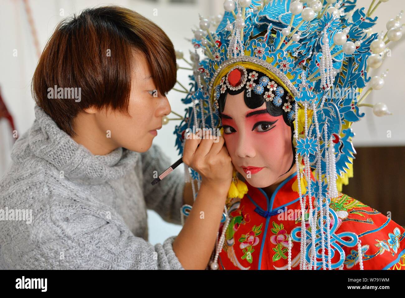 A primary student finishes her hair and makeup dressed as the role of ...