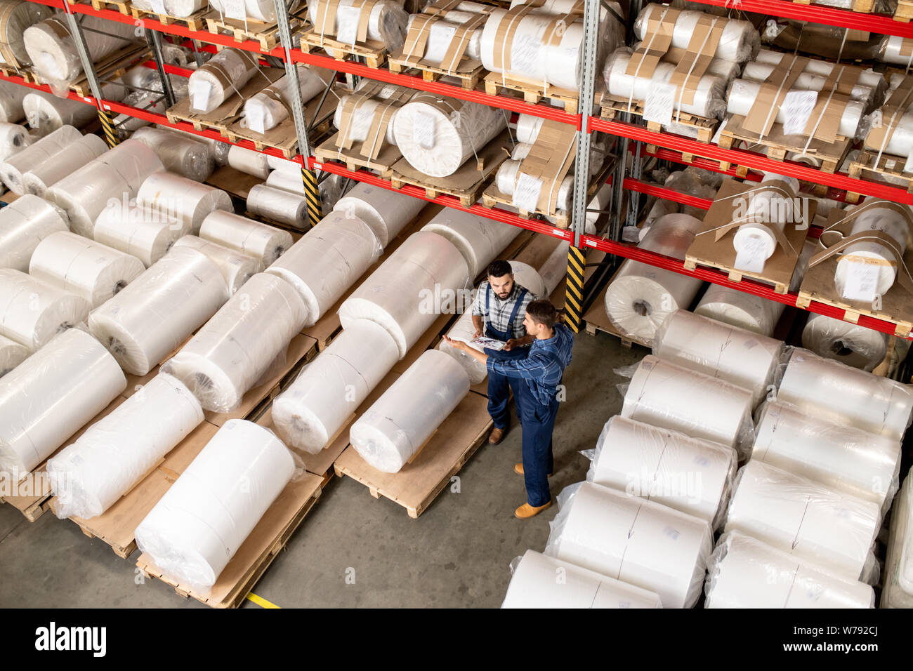 Two young technical experts in workwear discussing working moments at ...