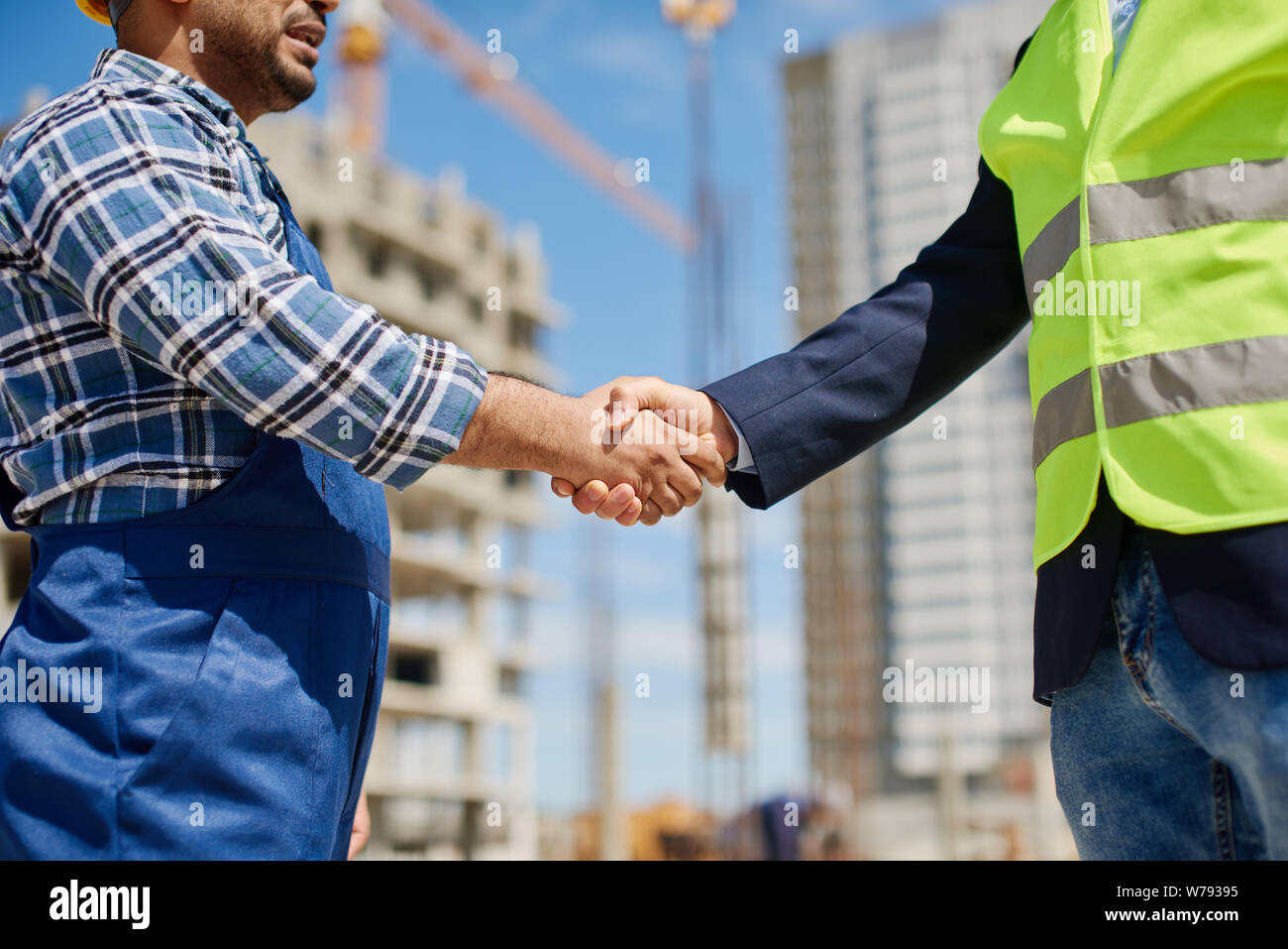 Two male engineers shake each others hands friendly Stock Photo - Alamy