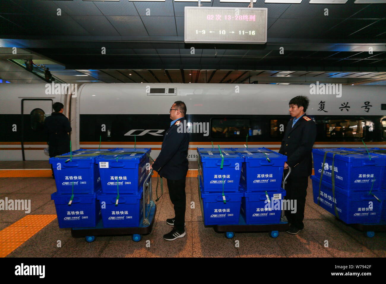 Chinese employees of CRE (China Railway Express) move the boxes with ...