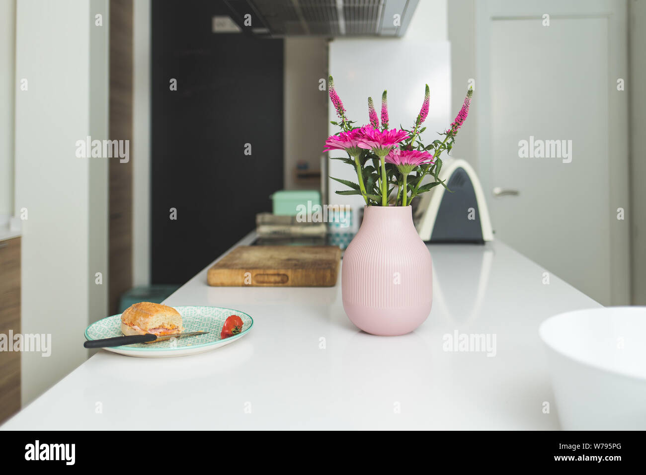 Pink flower bouquet decorating a white design domestic kitchen Stock ...