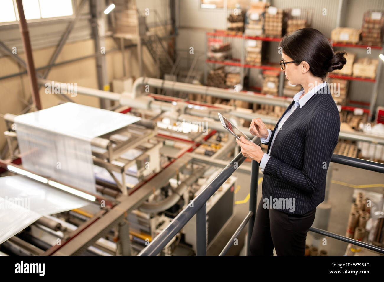 Young quality control expert with touchpad testing new industrial ...