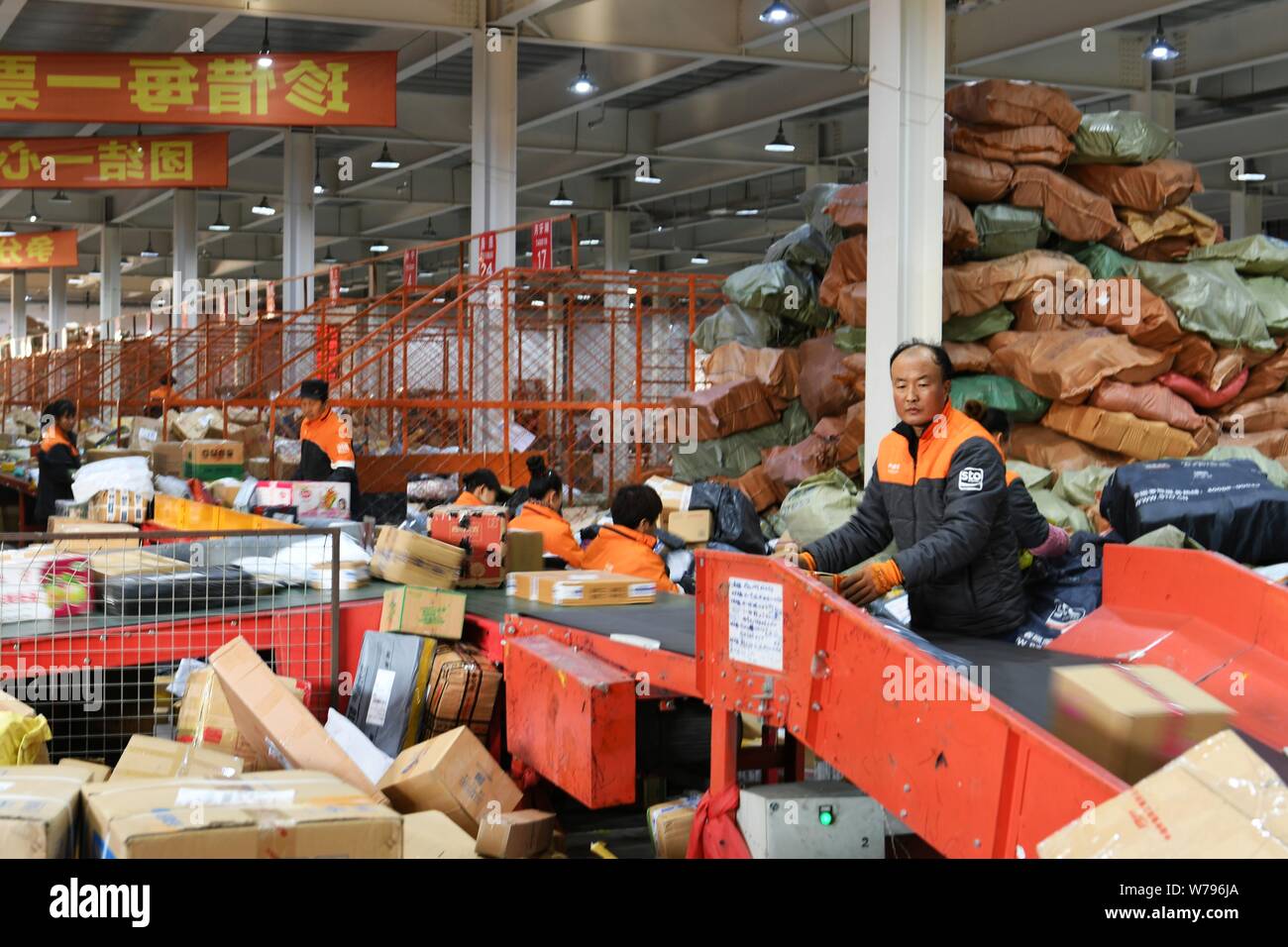 Chinese workers sort out piles of parcels, most of which are from Singles Day online shopping ...