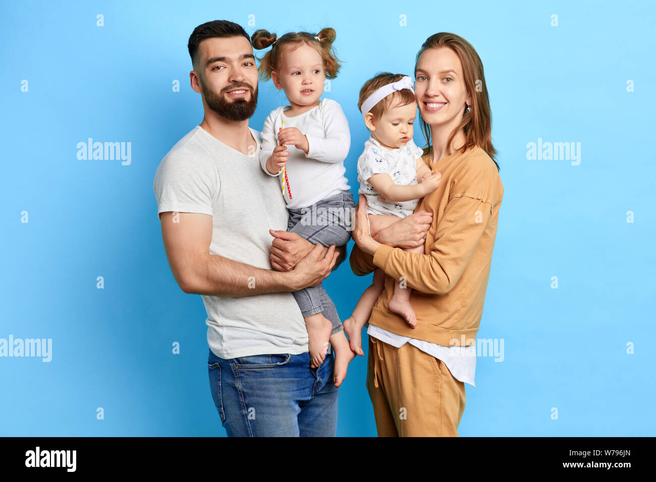 happy young couple and their kids posing to the camera. love ...