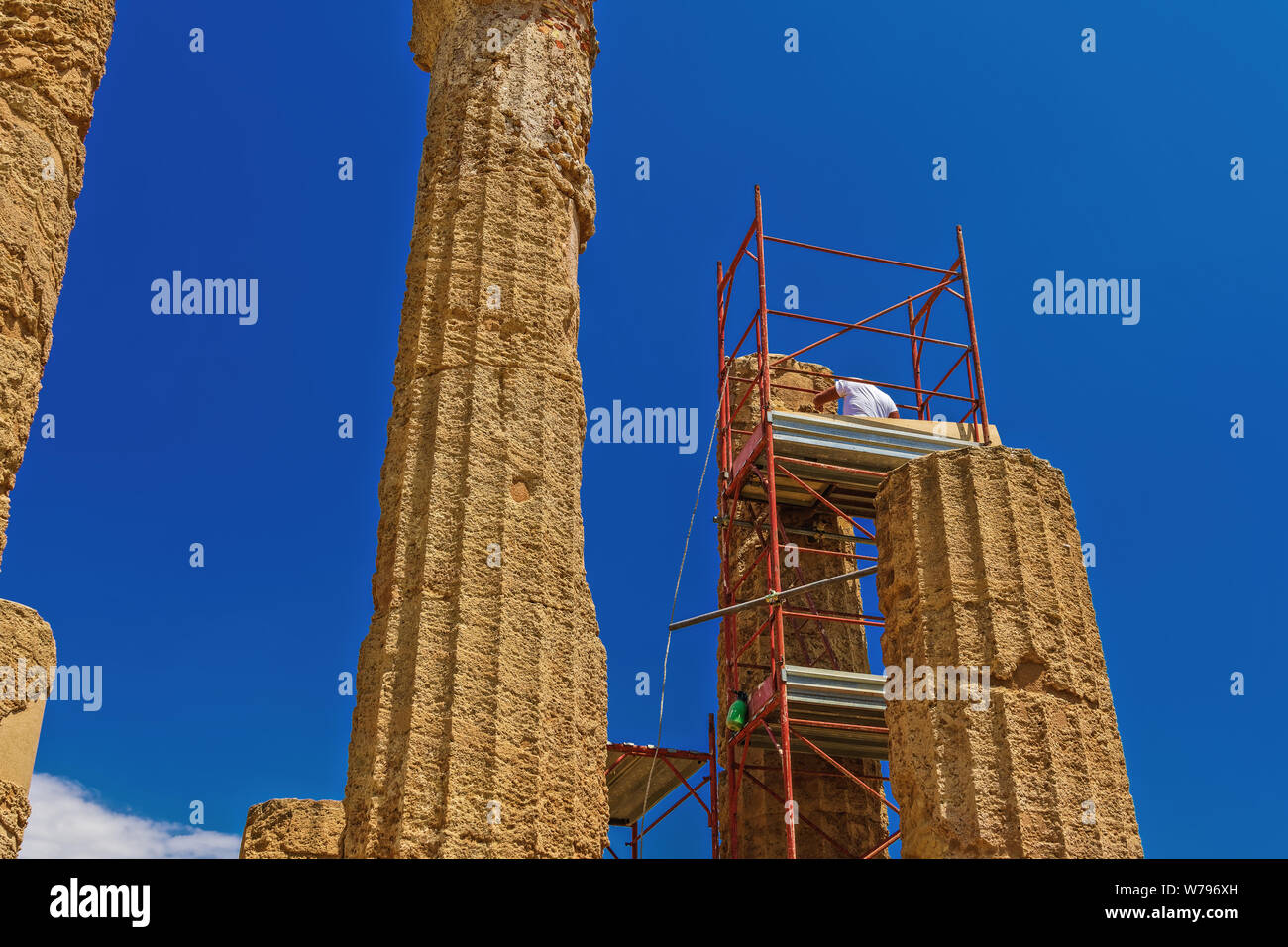 Ancient Greek Roman temple restoration scaffoldings. Worker on metal ...