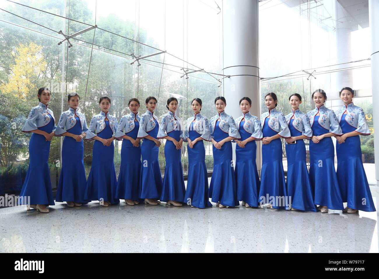 Chinese volunteers wearing cheongsam (qipao) pose during a ceremony for ...