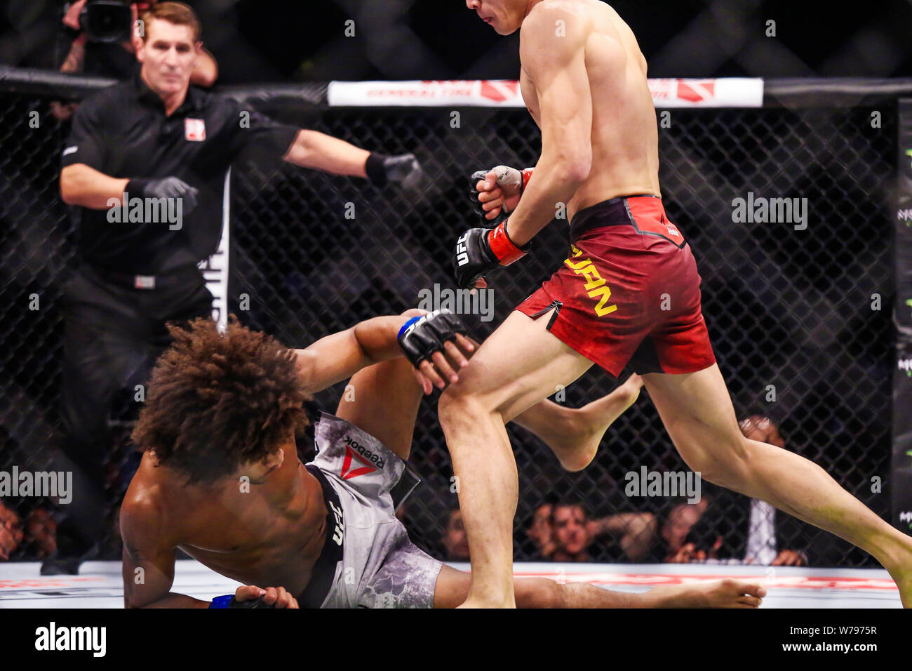 Chinese mixed martial artist Wang Guan, right, hits American mixed martial artist Alex Caceres ...