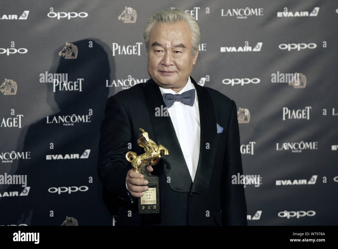 Chinese actor Tu Men poses with his trophy of the Best Leading Actor ...