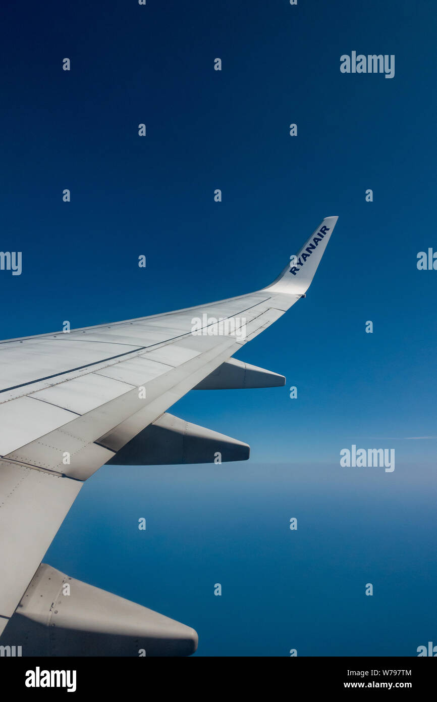 view of a Ryanair Boeing 737 - 800 wing out of plane window in flight ...