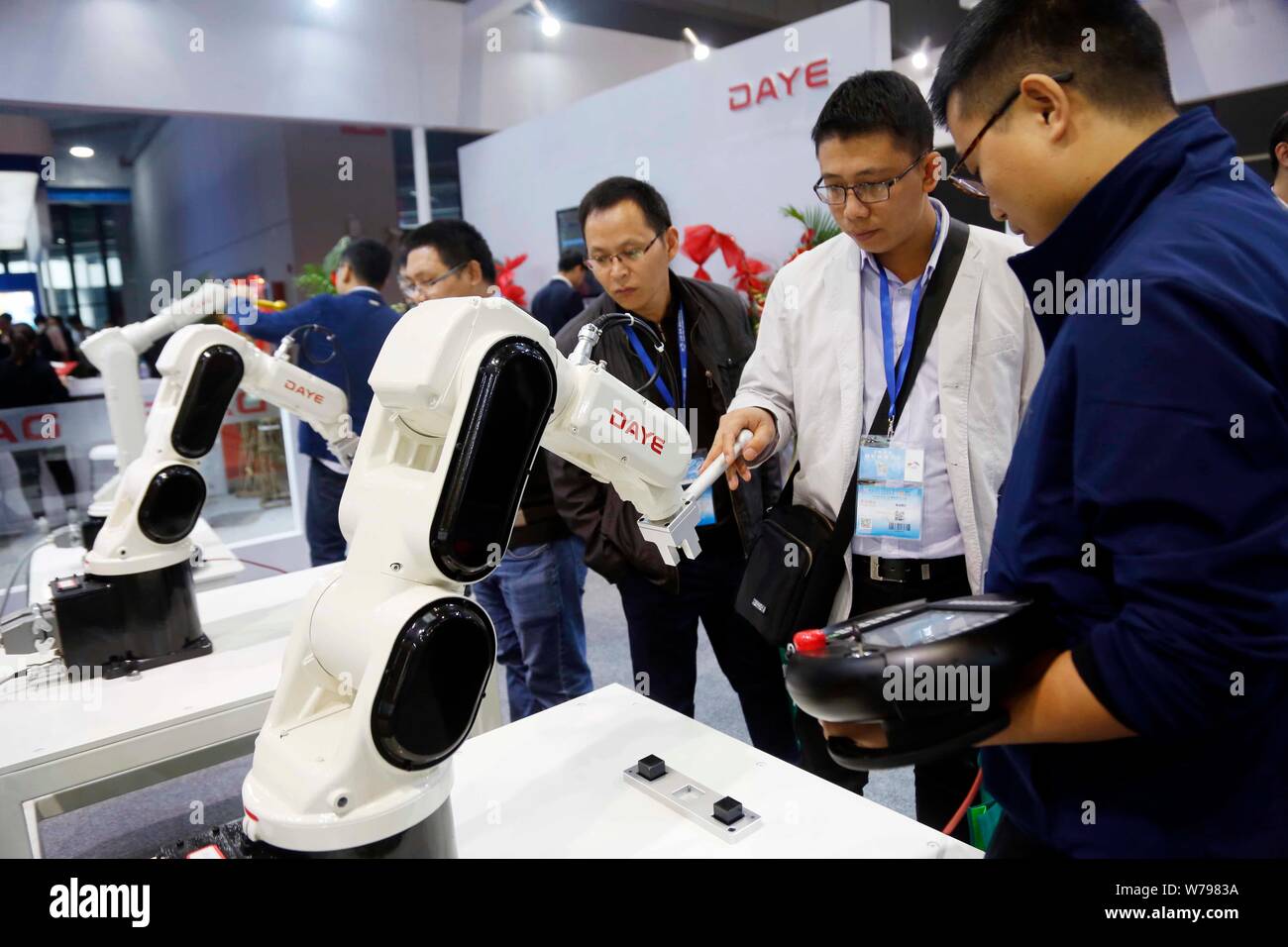 An exhibitor interacts with a robot arm supporting human-machine ...