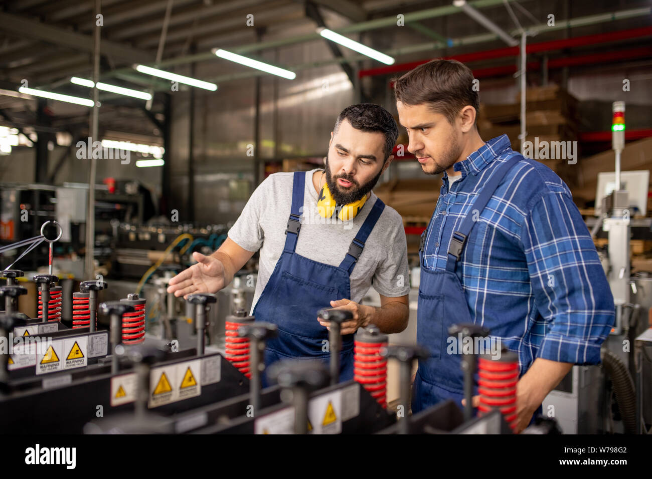 Bearded engineer explaining principles of work of new processing ...