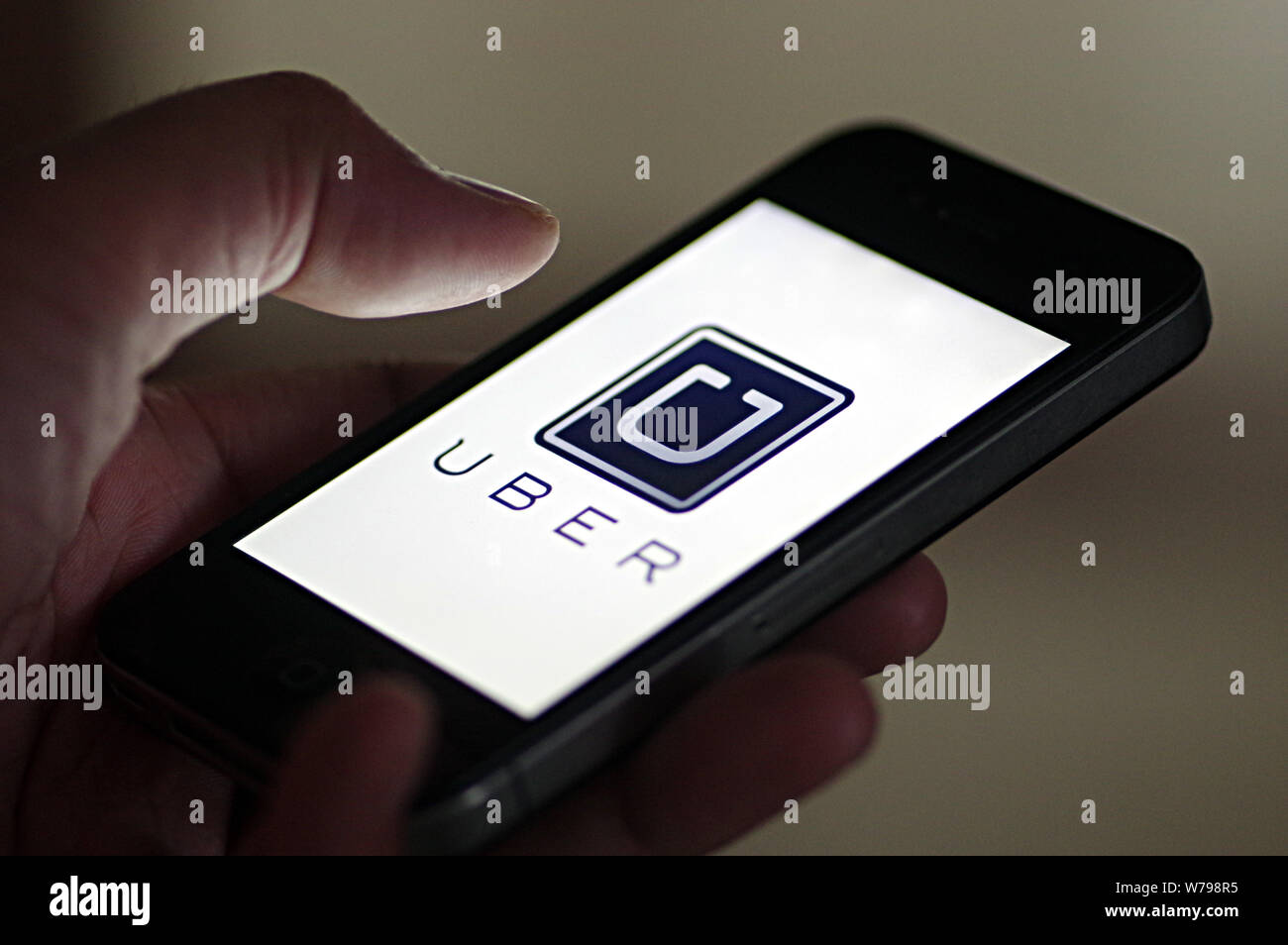 --FILE--A local resident looks at a logo of taxi-hailing and car ...