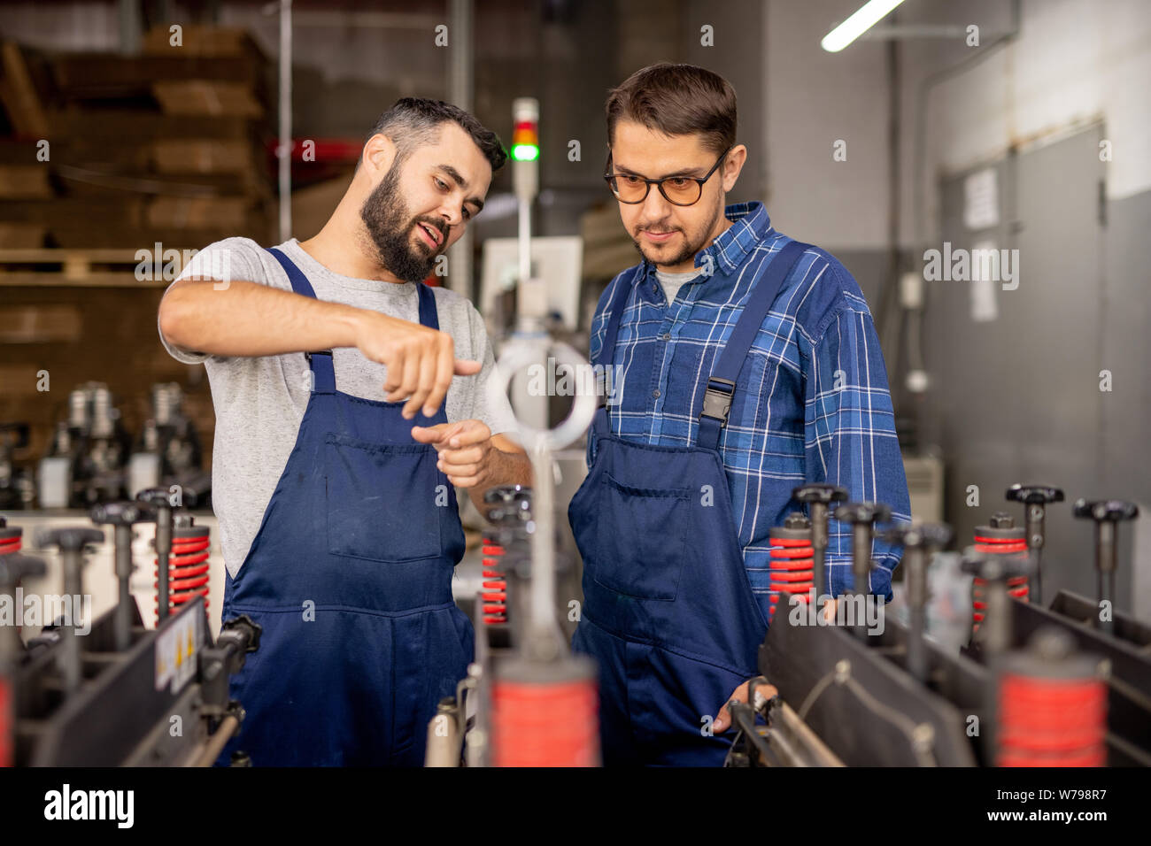 Young engineer explaining his trainee how to serve and use technical ...