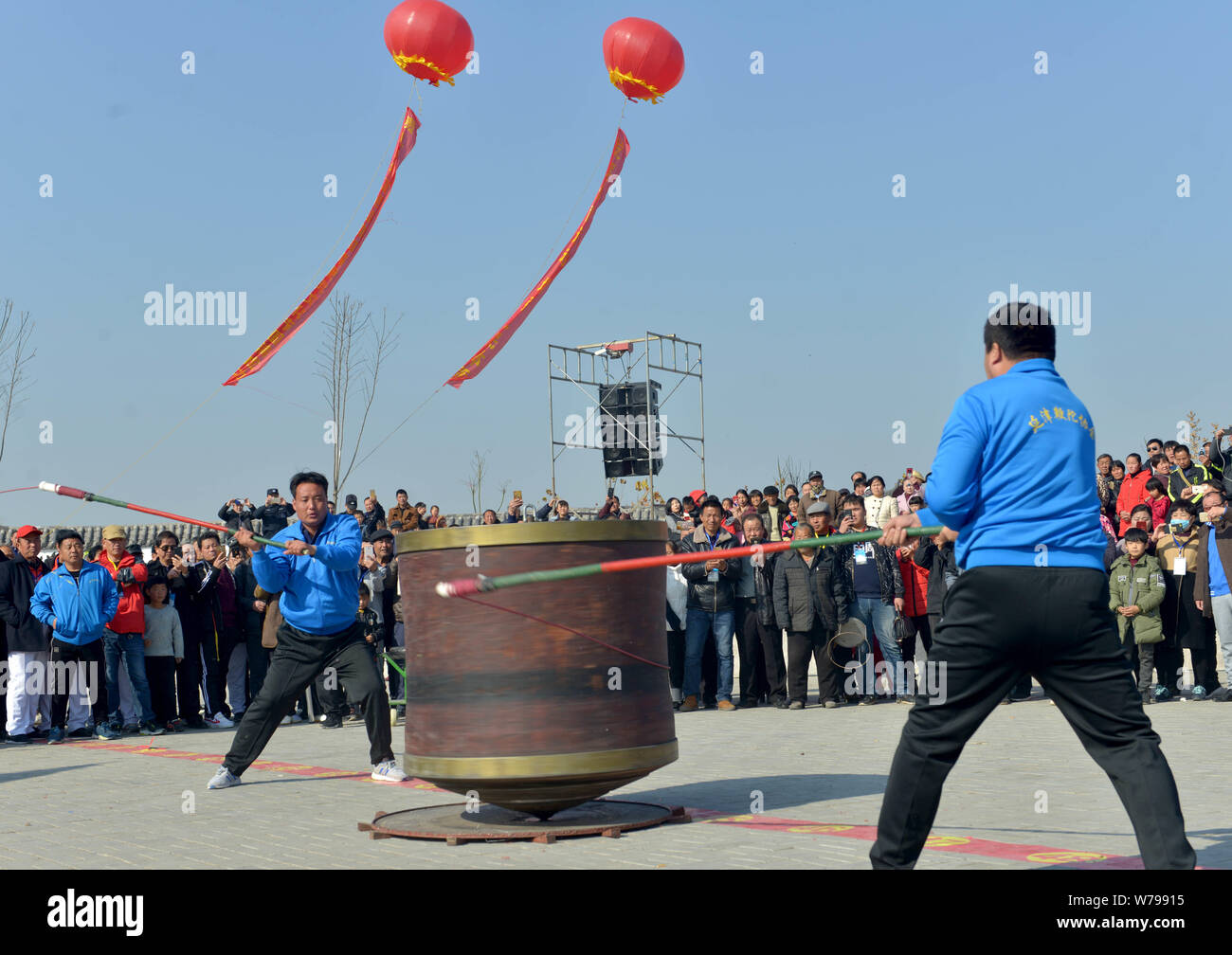 Chinese participants whip the 2,000 kilograms spinning top to keep it ...