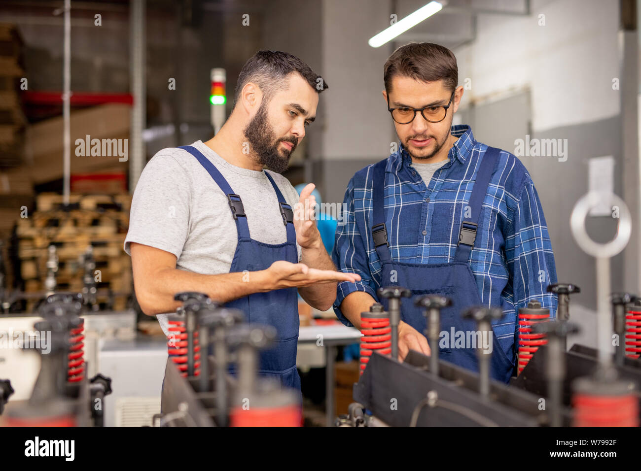 Professional machinery engineer giving instructions to his trainee ...