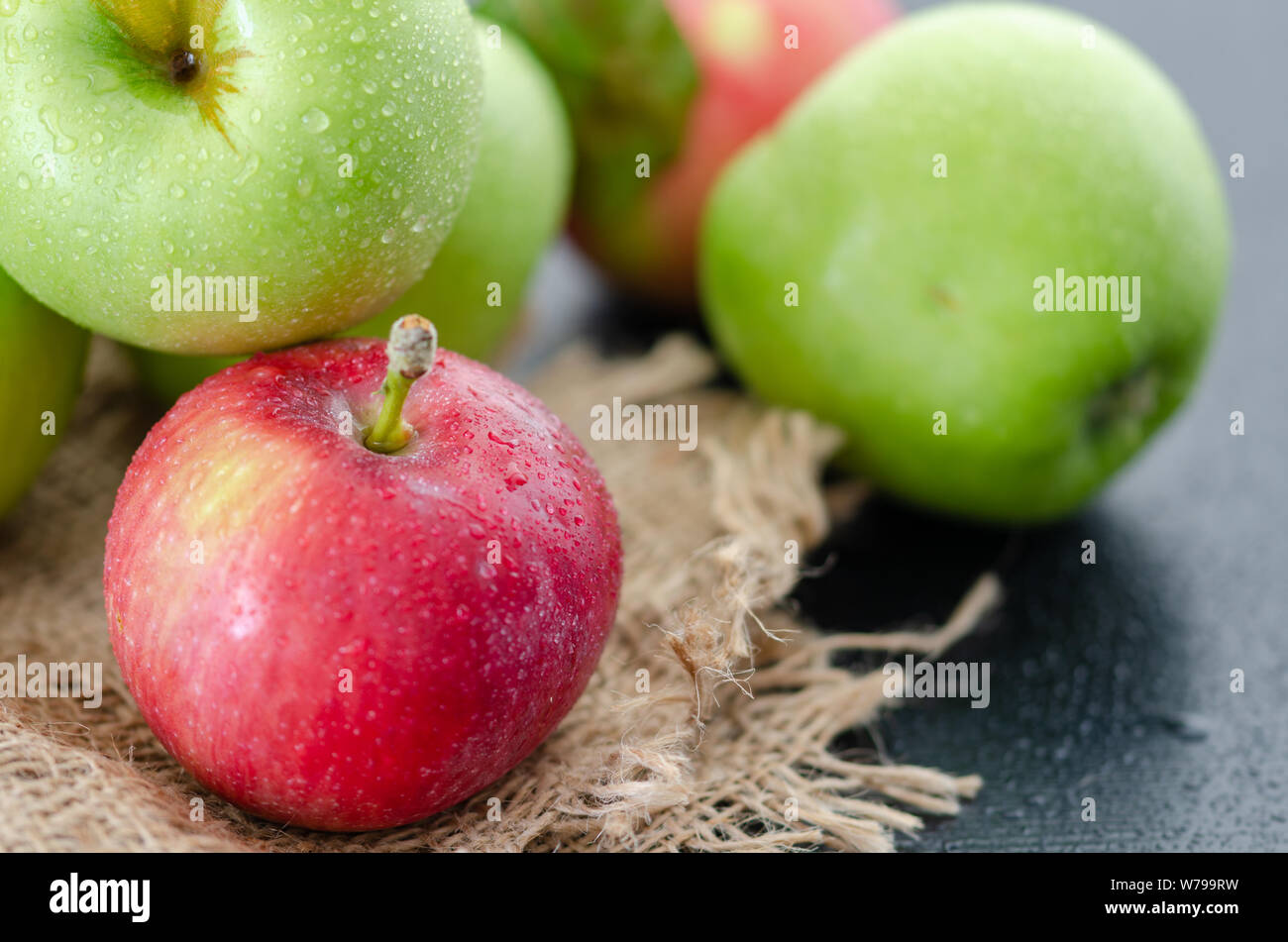 A group of different colors of apples on a black table. Horizontal and ...