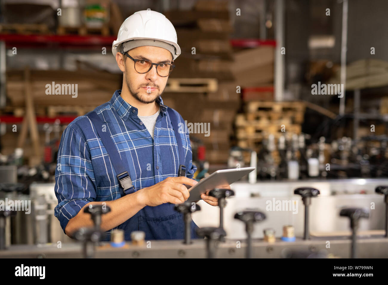 Young serious employee of industrial plant testing new technical ...