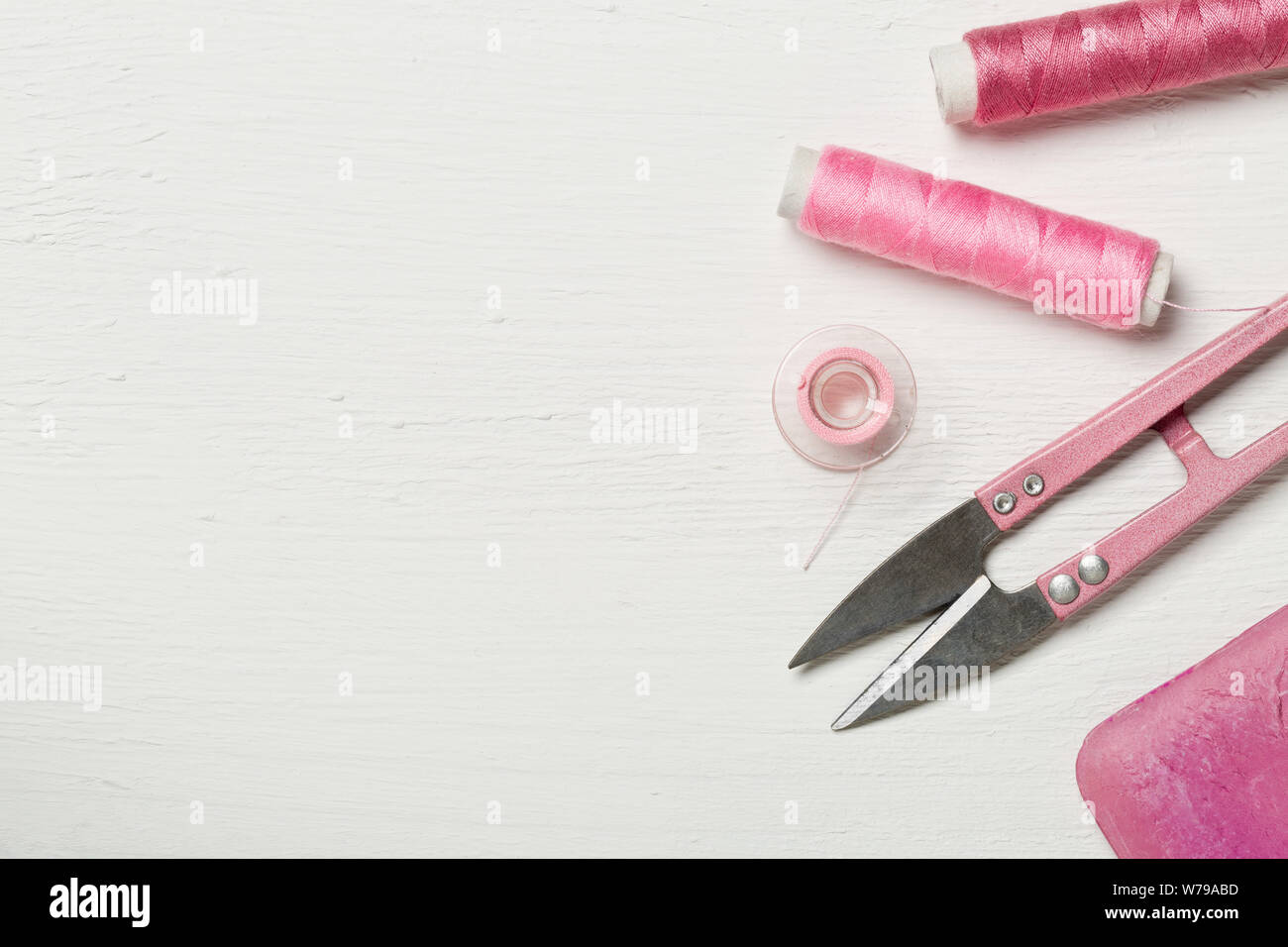 Pink colored flat lay top view sewing tools with texile fabric, chalk ...