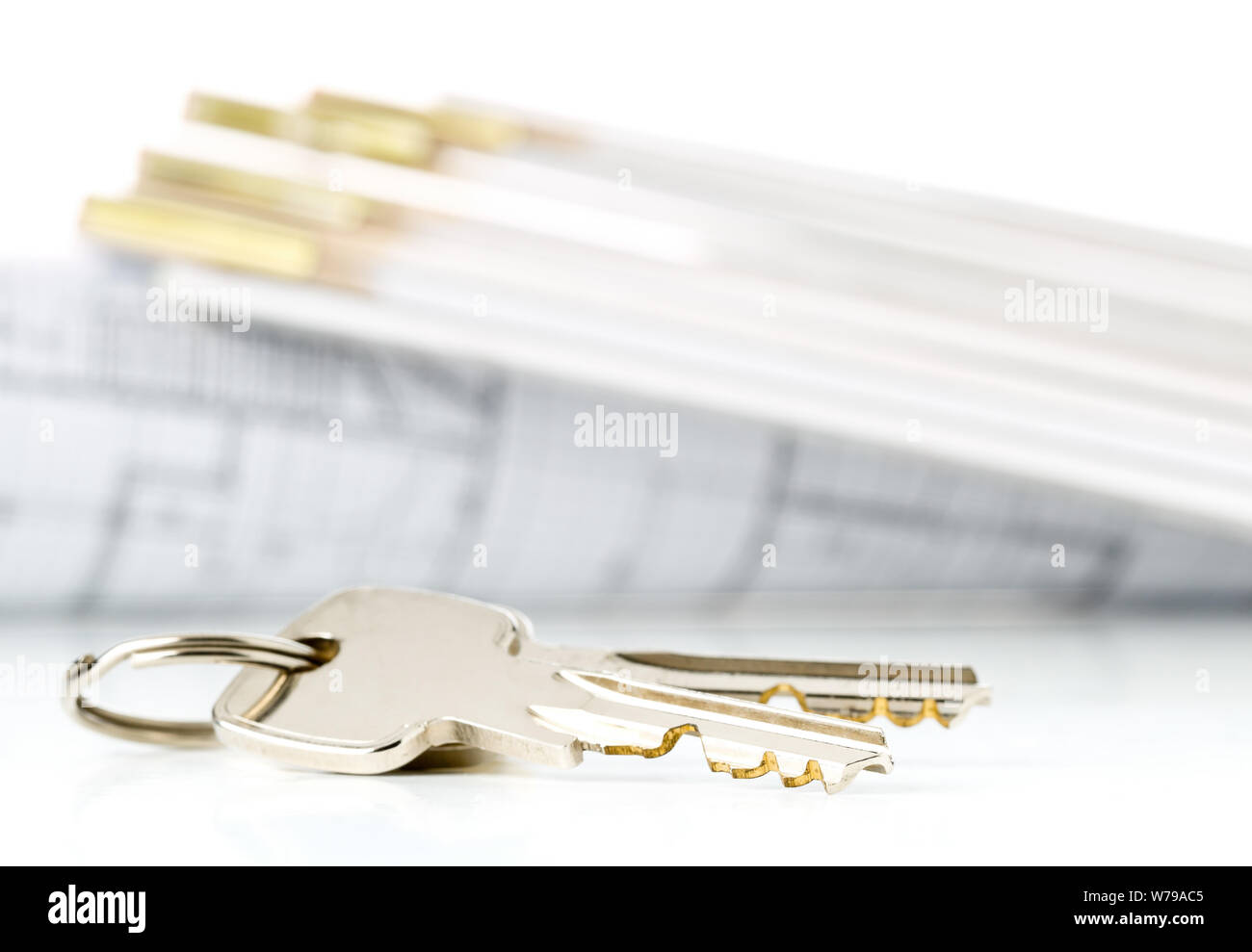House keys in front of house architectural blueprint and folding rule ...