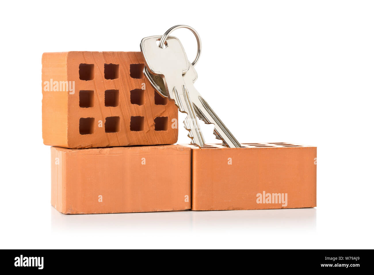 House keys on bricks over white background with selective focus - home ...
