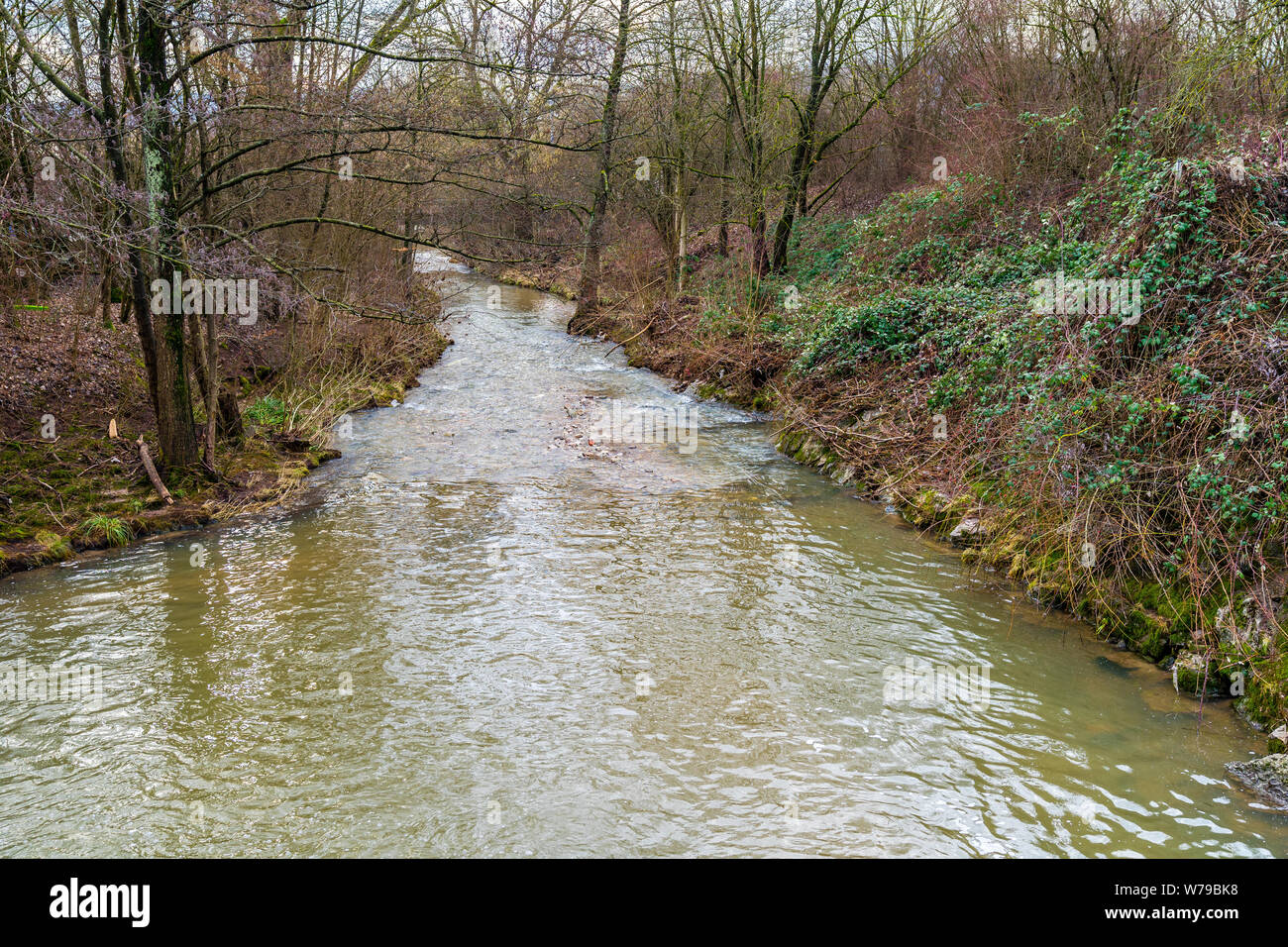 Water of natural river flowing through green countryside Stock Photo ...