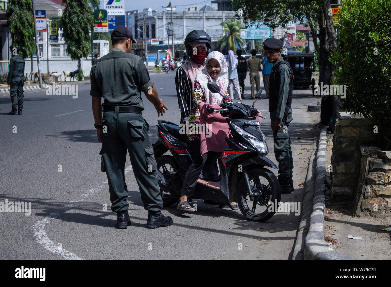 A motorcyclist stopped by Sharia police during the enforcement.Dozens ...