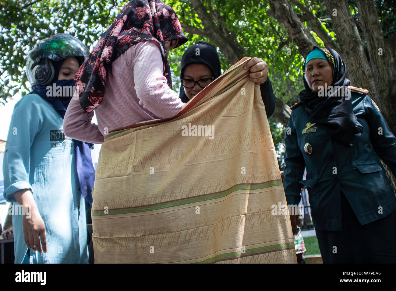 Sharia police officers dress a woman during the enforcement.Dozens of ...