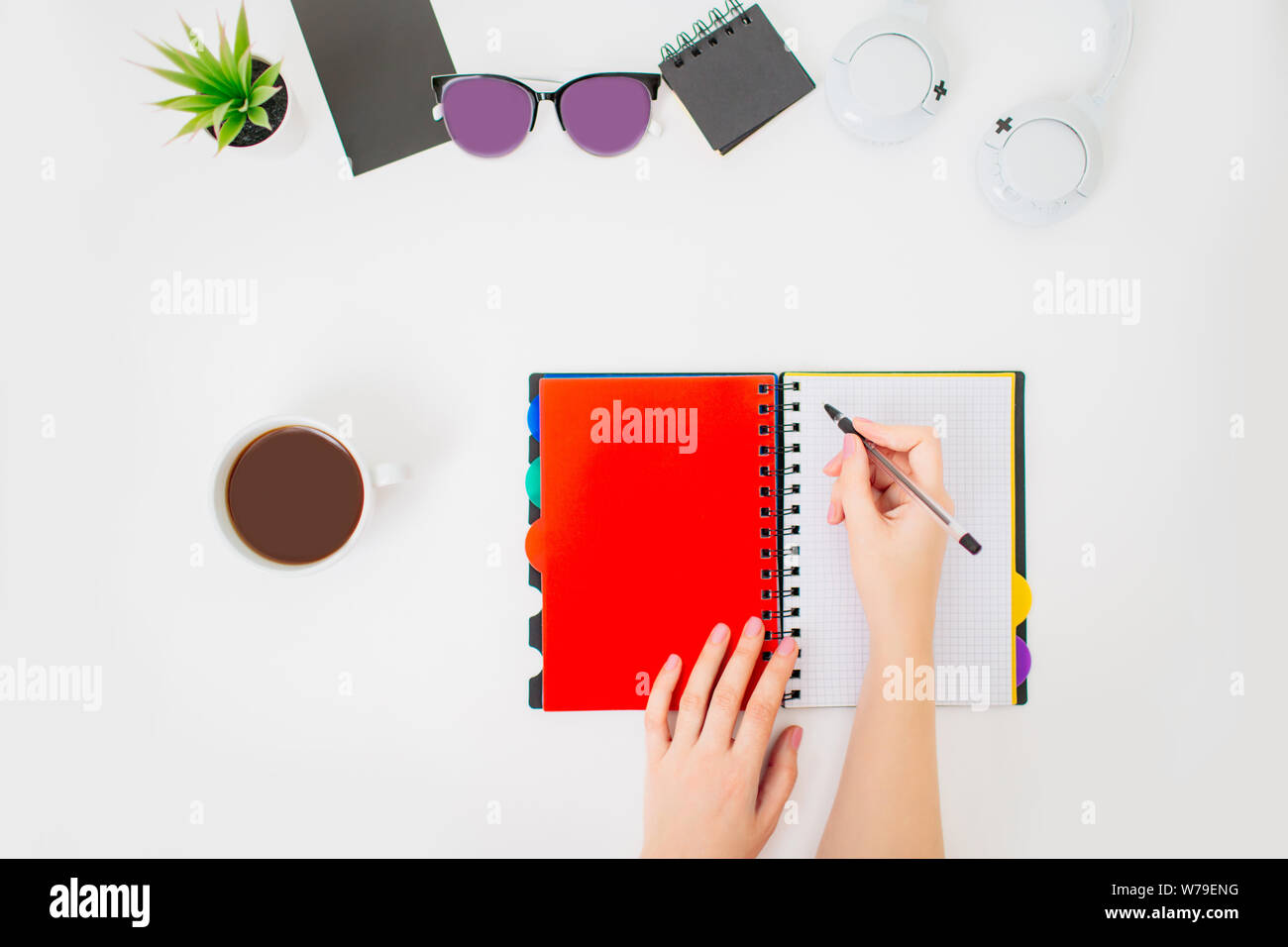 Flatlay with female hands making notes in a notepad. Minimalistic ...