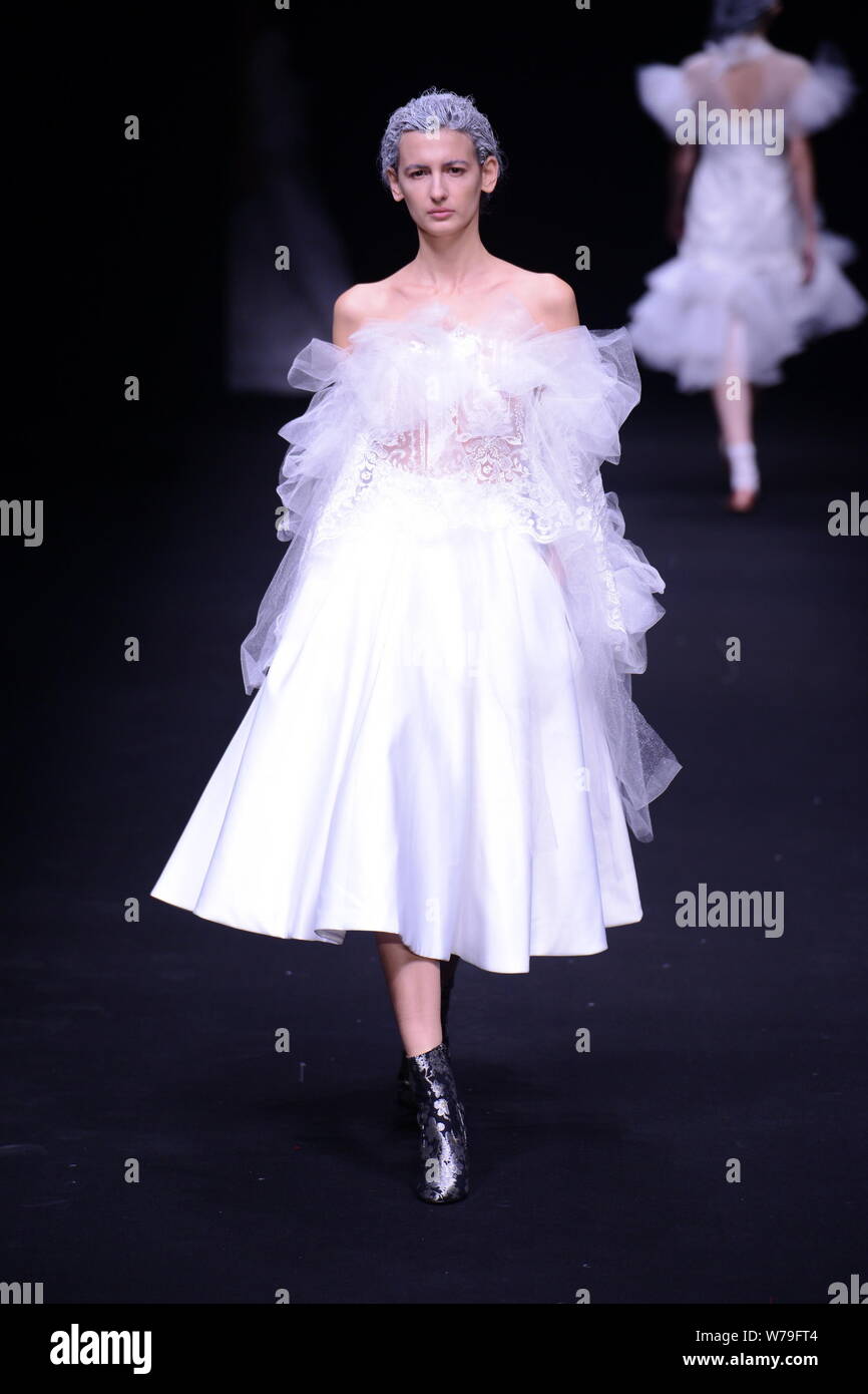 A model displays a new creation at the fashion show of Mid Time & Mija ...