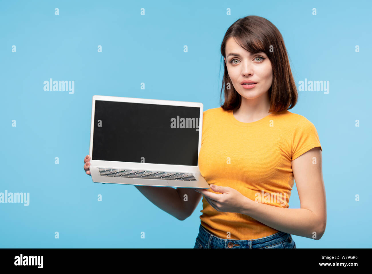 Young clever student holding laptop while making presentation Stock ...