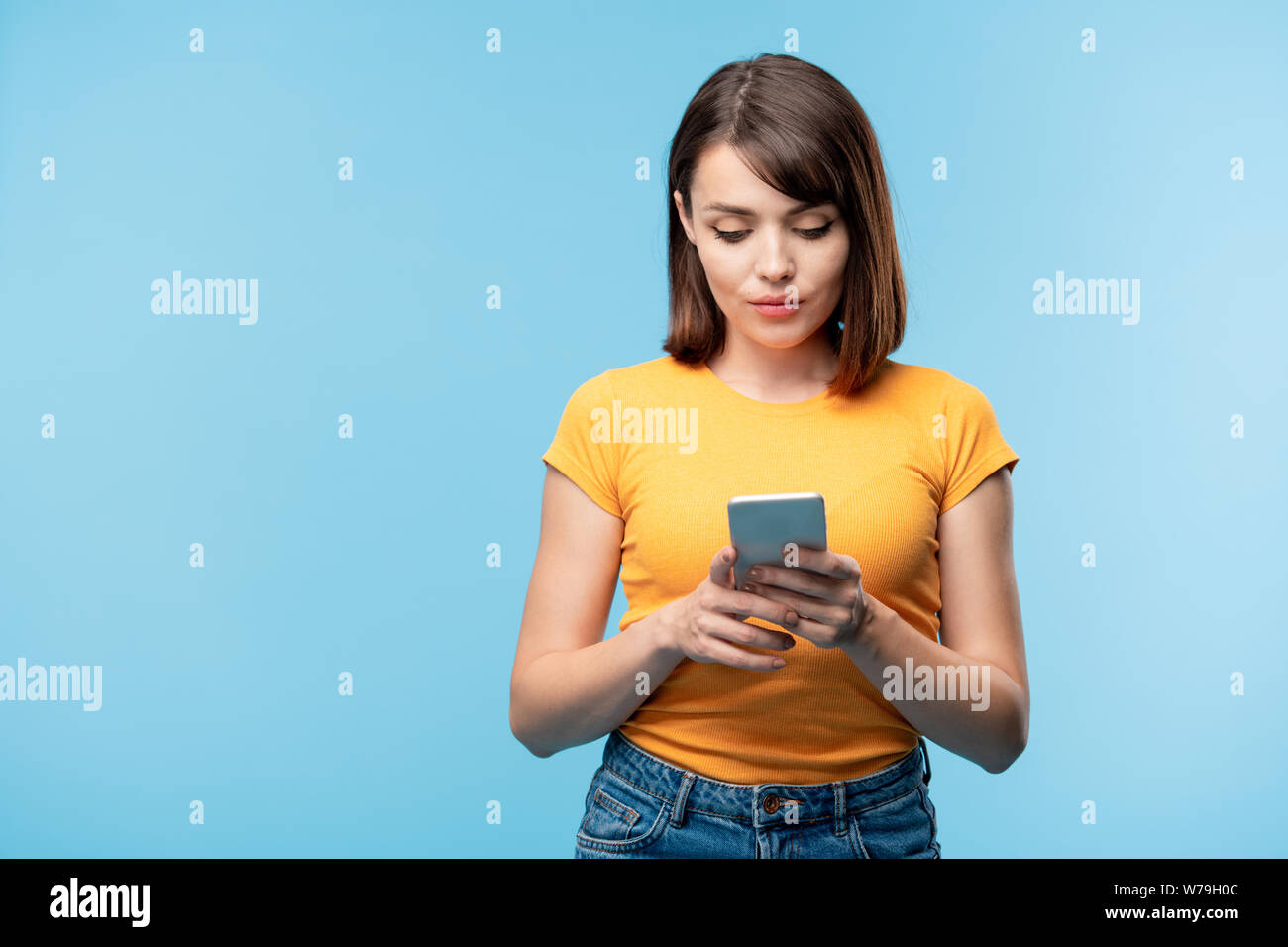 Pretty young serious woman scrolling in smartphone Stock Photo - Alamy