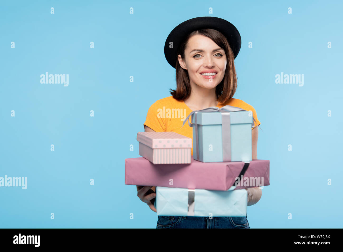 Pretty shopper holding stack of packed and wrapped gifts for holiday ...