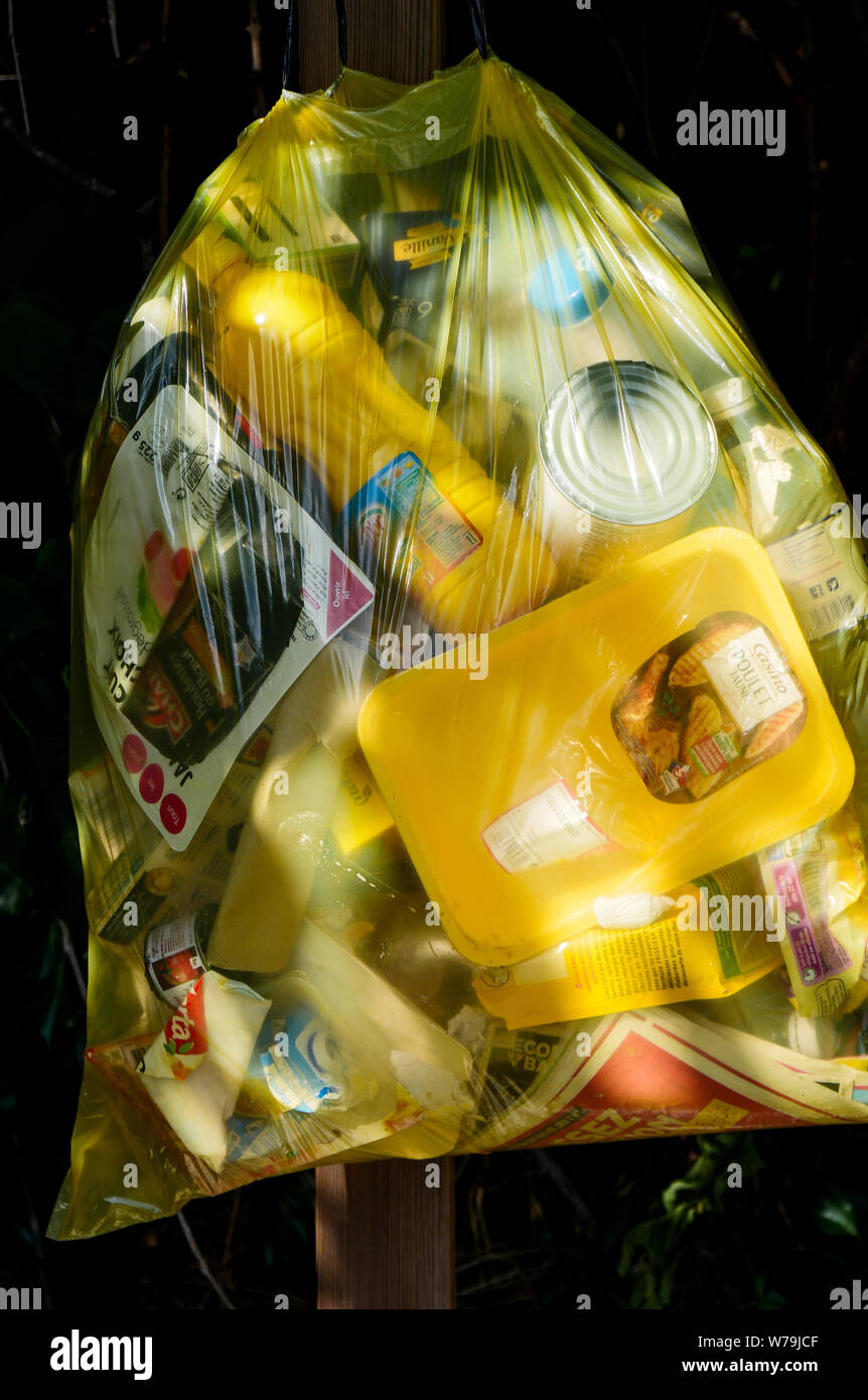 A yellow plastic bag filled with recyclable items hangs at a "Sorting ...