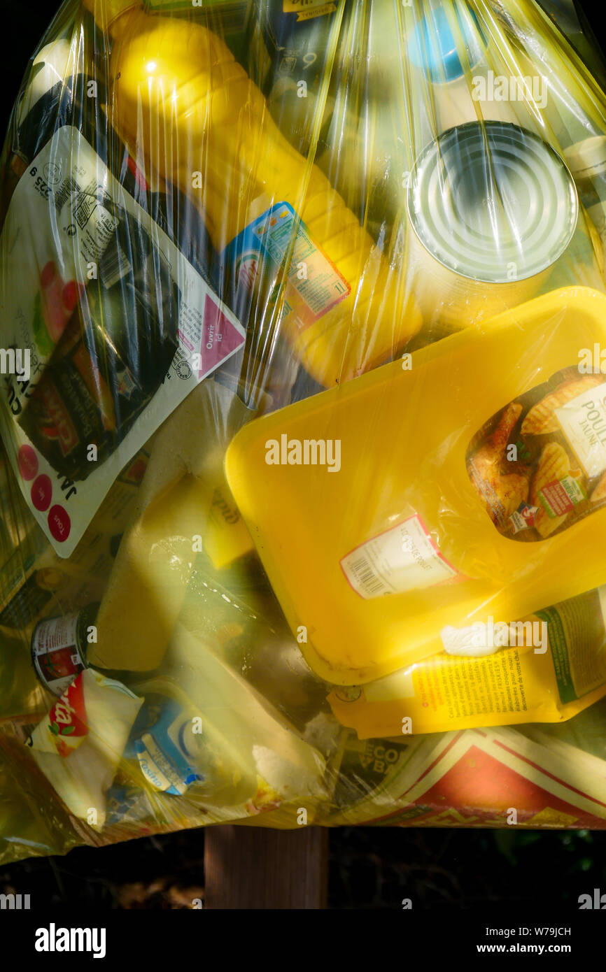 A yellow plastic bag filled with recyclable items hangs at a "Sorting ...
