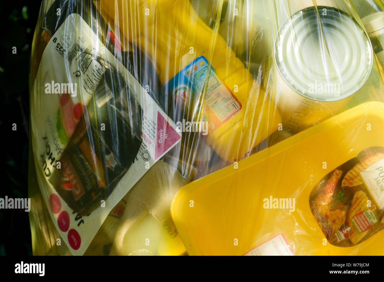 A yellow plastic bag filled with recyclable items hangs at a "Sorting ...